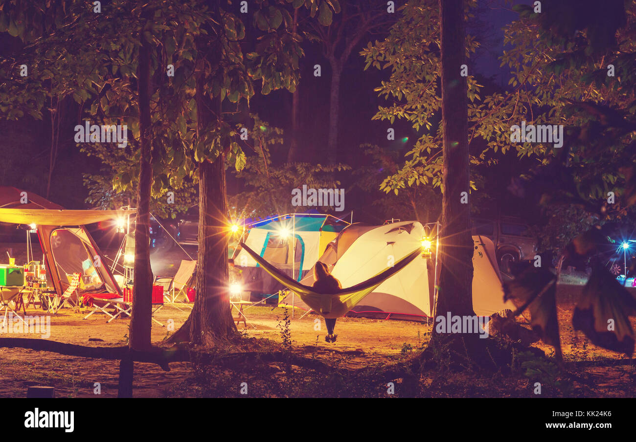 Amazing scene in night camping -girl in hammock on tents background ...
