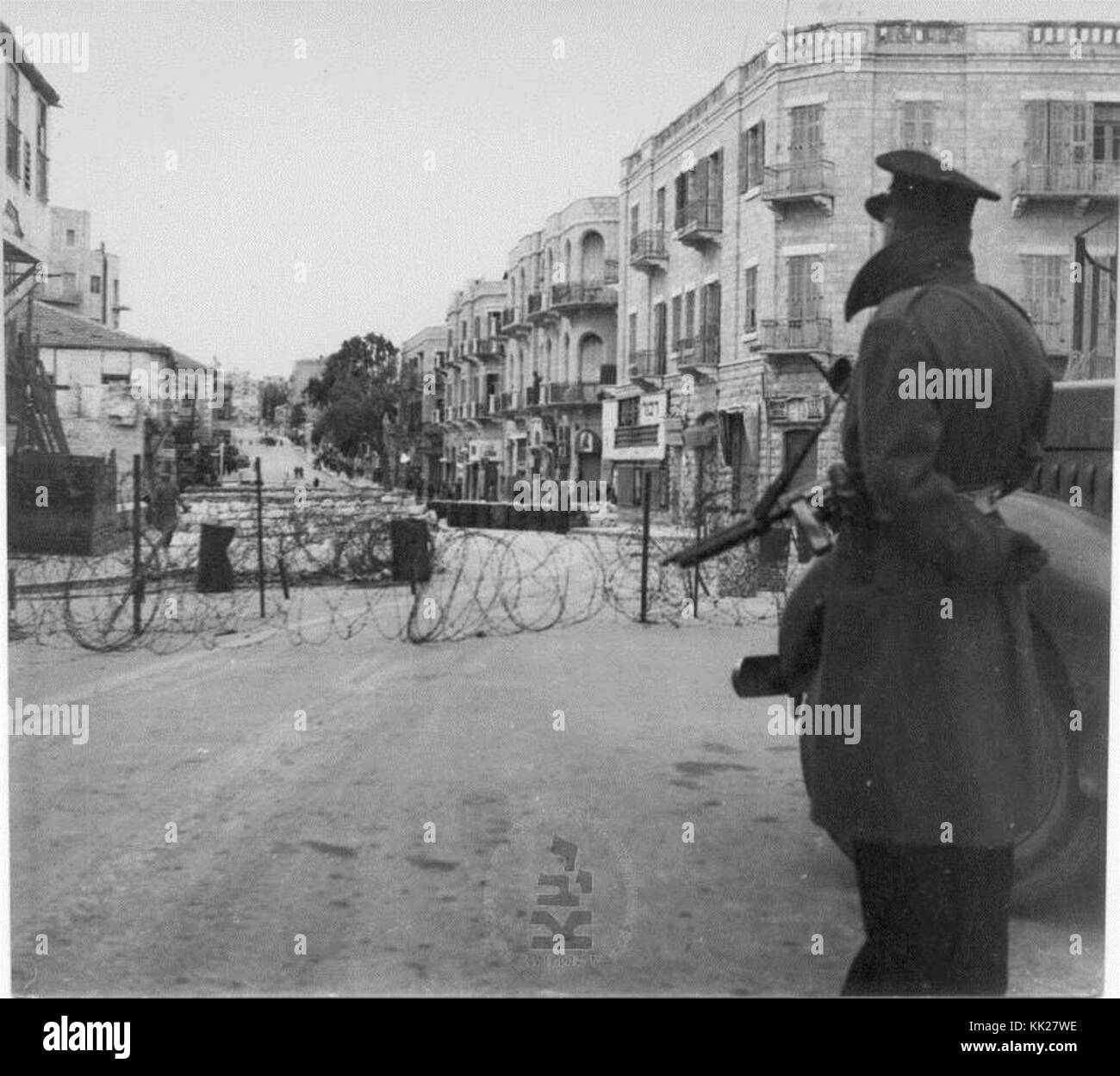 An Israeli policeman looks toward a barbed wire fence on Jaffa street ...