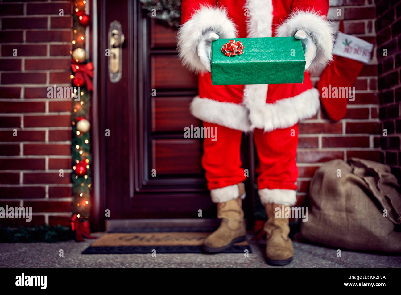 Close up of Christmas gift in Santa Claus hands in front of door ...