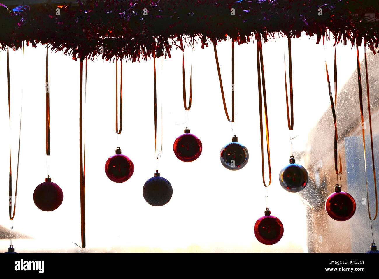 Christmas baubles hanging from tinsel in window during daylight hours ...