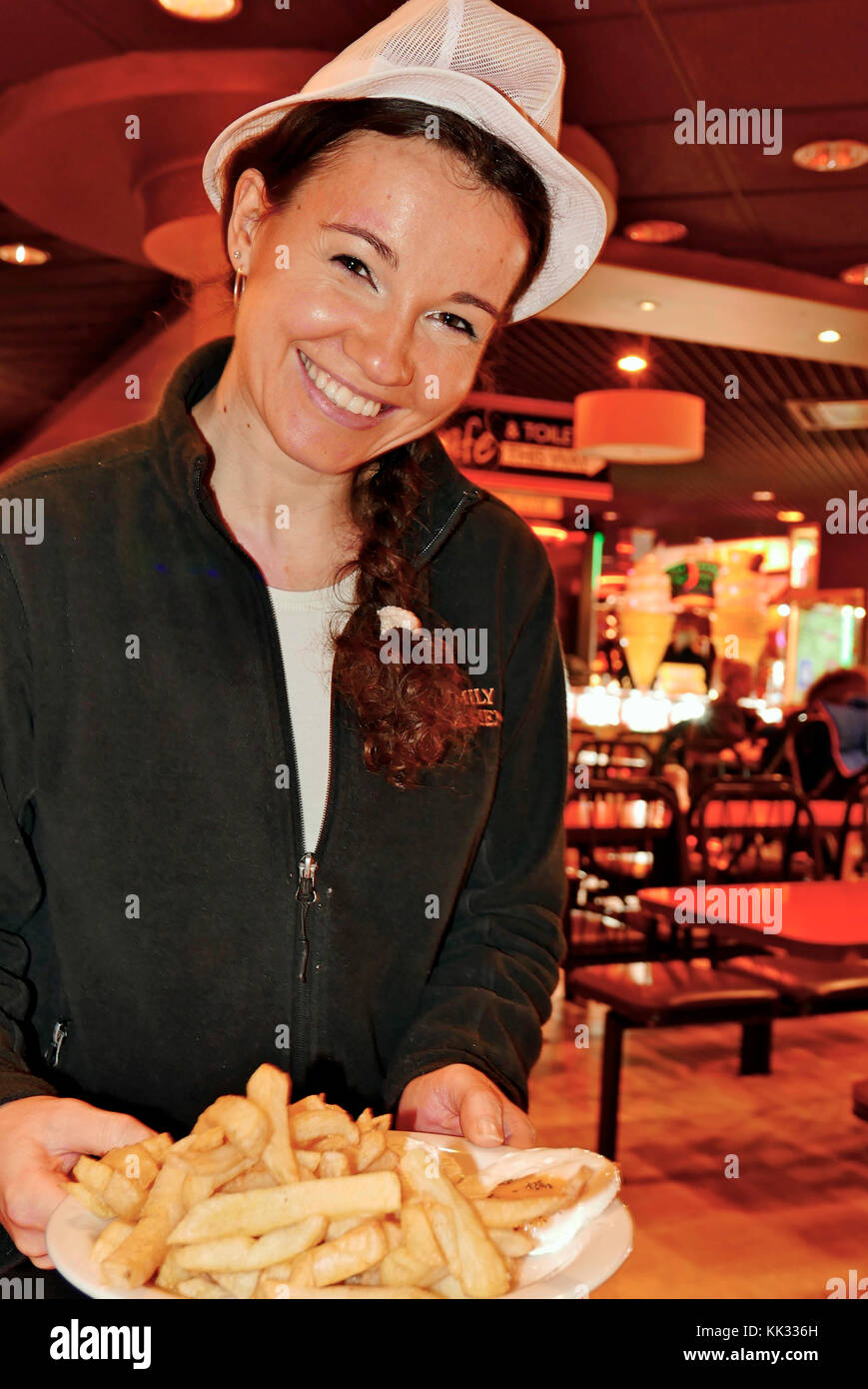 Smiling young waitress in fish and chip restaurant on Blackpool ...