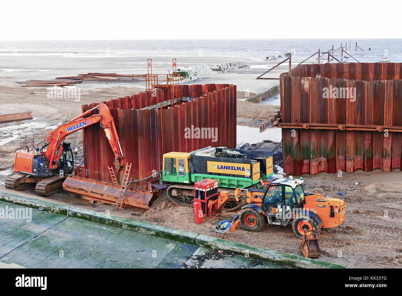 Marine engineers working on cofferdams at low tide during construction ...