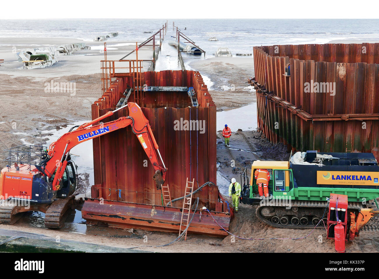 Marine engineers working on cofferdams at low tide during construction ...