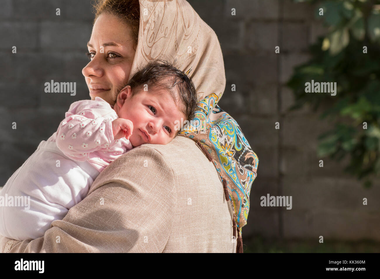 Muslim mother caring a little newborn baby in outdoor environment ...