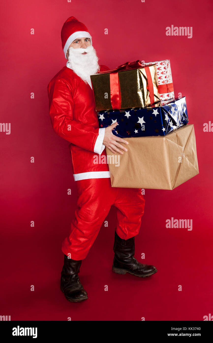 Santa Claus is carrying heavy gifts Stock Photo - Alamy