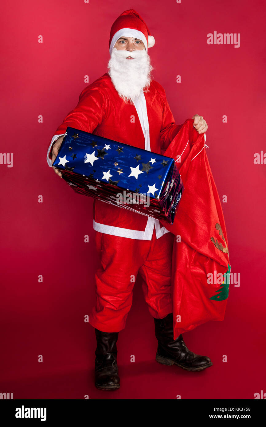Santa Claus gives away presents from his gift bag Stock Photo - Alamy