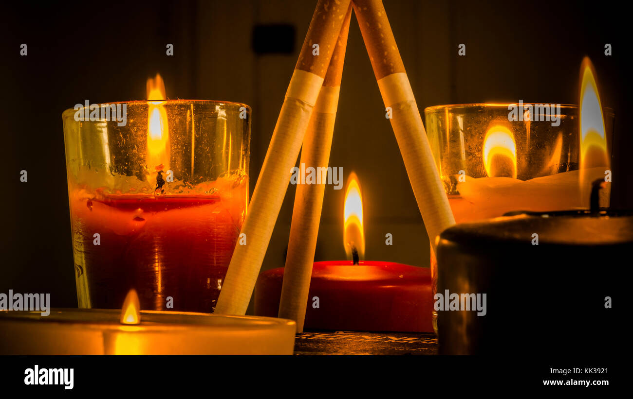 Different configurations with cigarettes and burning candles Stock ...