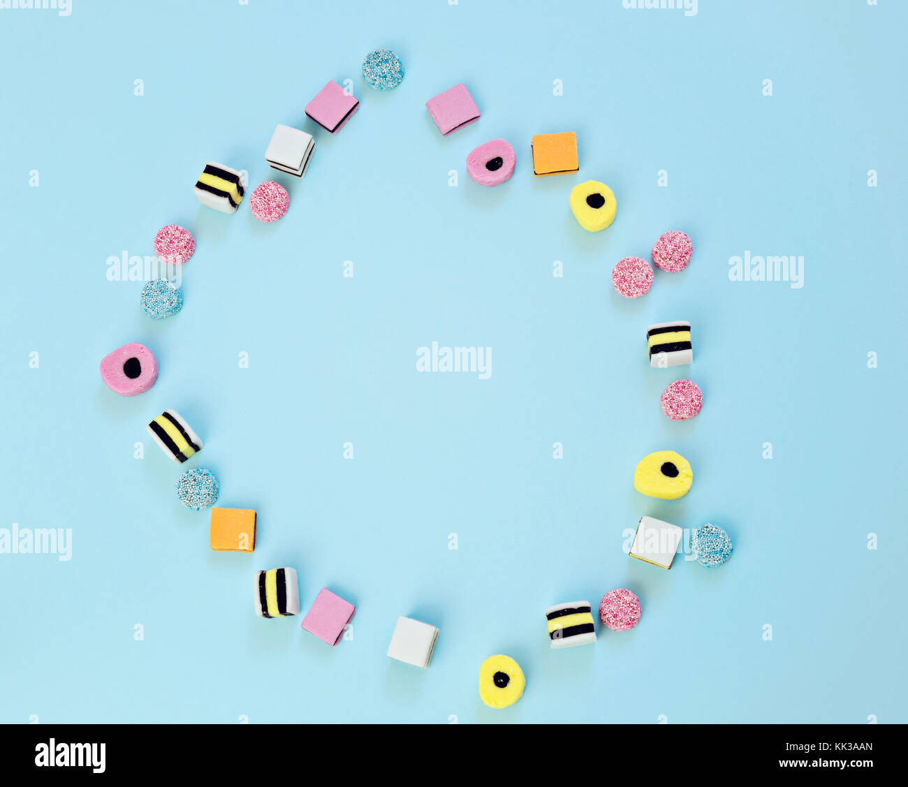 Colored sweets are scattered on a blue background Stock Photo - Alamy