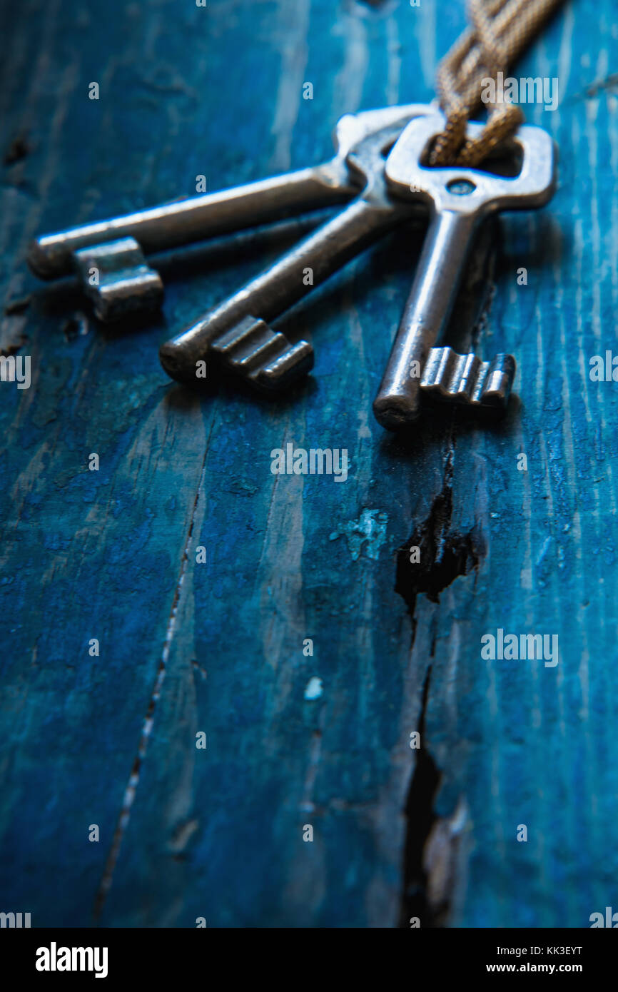 Three antique keys on wooden table Stock Photo - Alamy