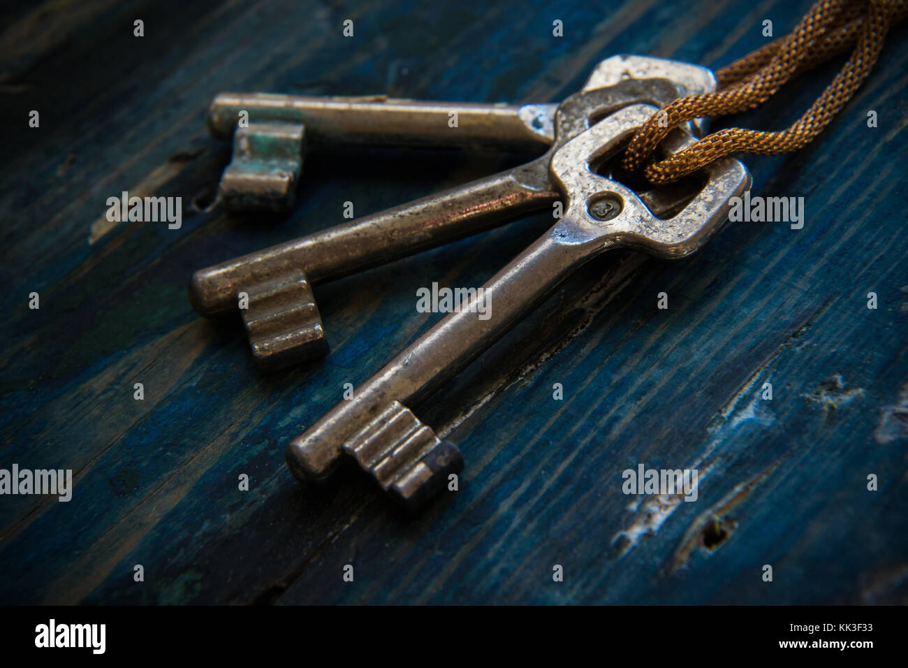 Three antique keys on wooden table Stock Photo - Alamy