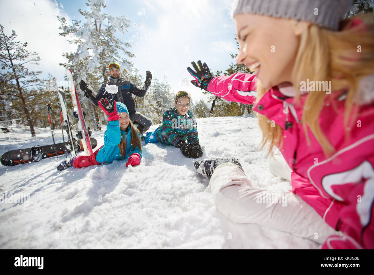 Family on winter holiday making snowballs and having fun Stock Photo ...