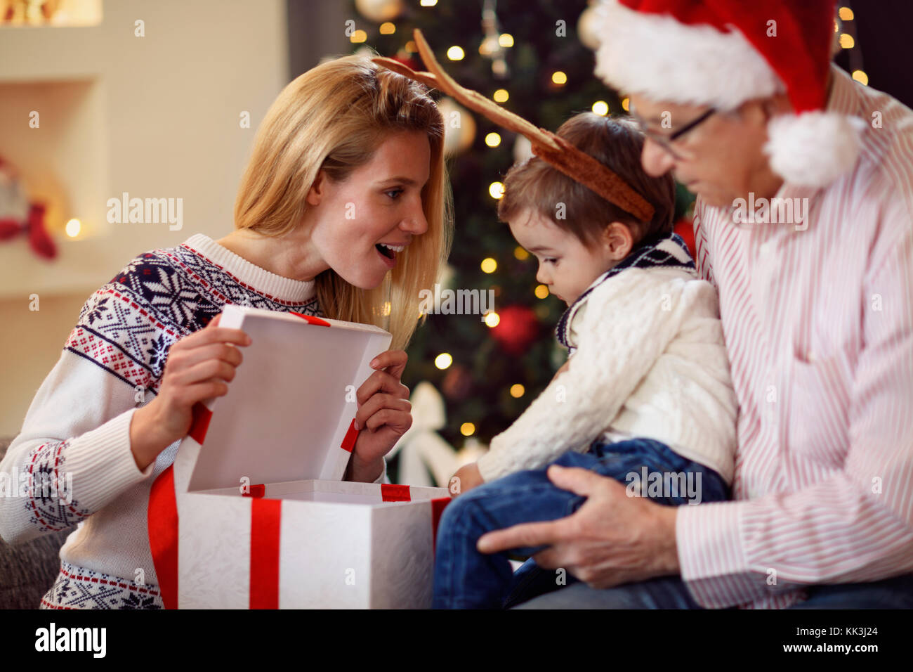 sharing gift on Christmas- smiling mother giving present to young son ...