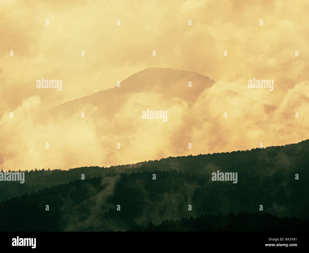 Distant mountain range and heavy clouds of colorful mist above deep ...