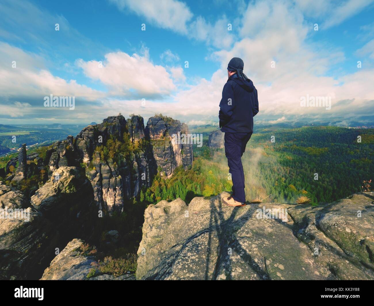Hiker in black sportswear stand on the peak of sandstone rock in rock ...