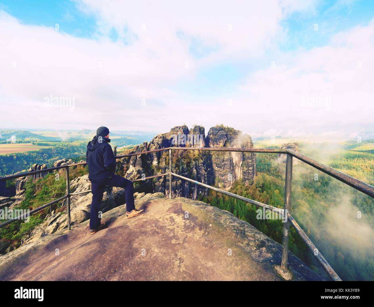 Hiker in black sportswear stand on the peak of sandstone rock in rock ...