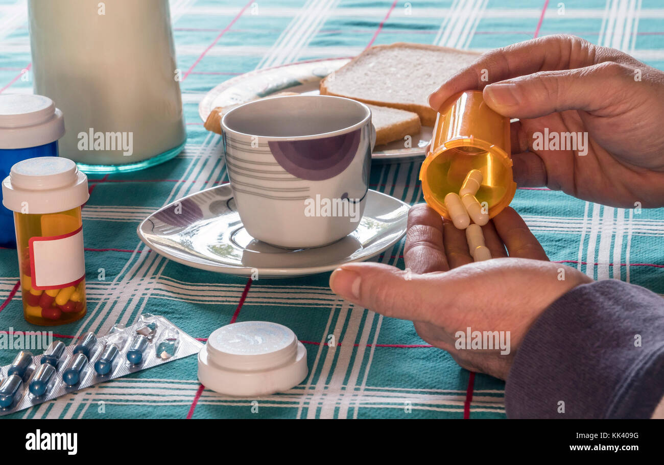 Person takes medication during breakfast, conceptual image Stock Photo ...