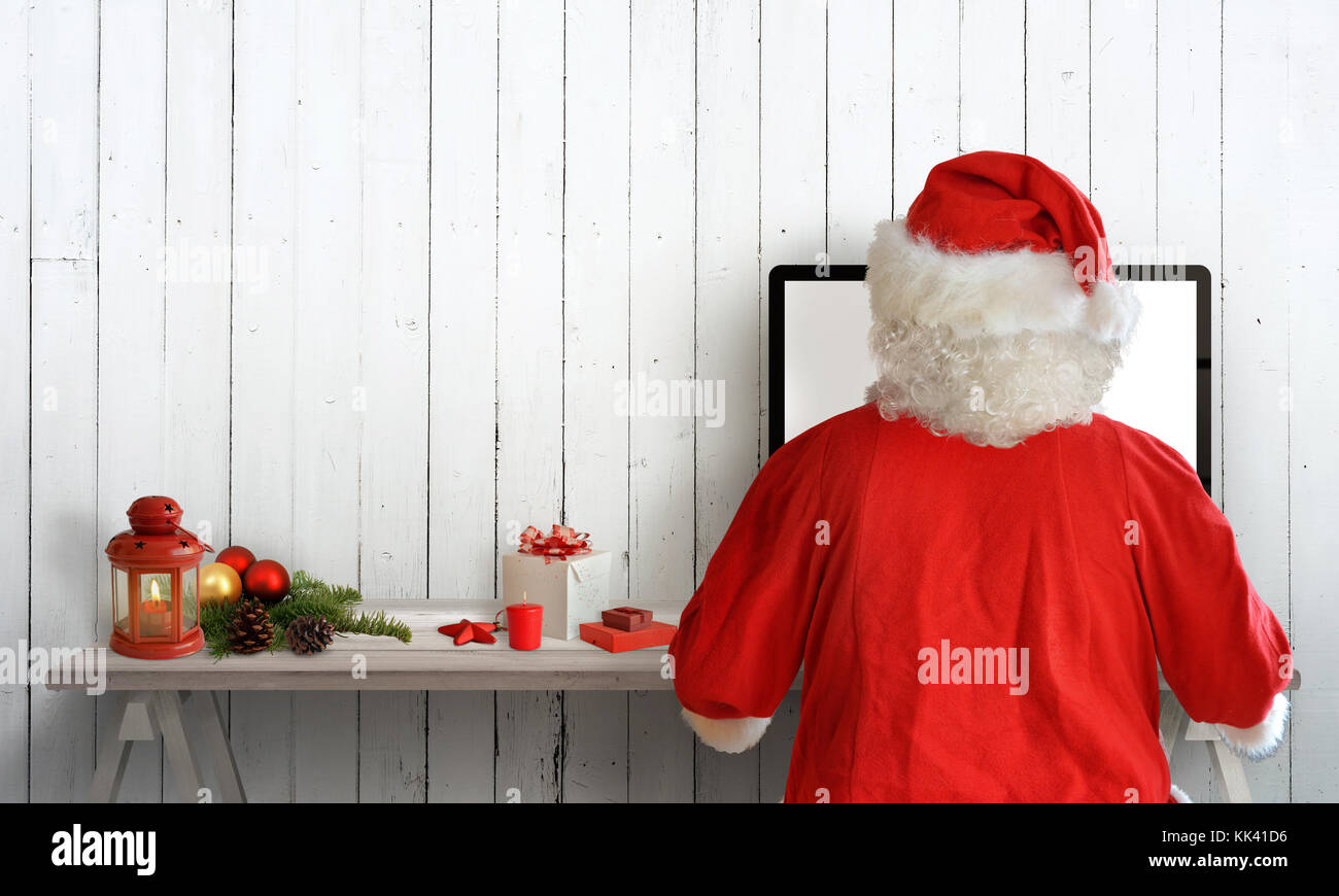 Santa Claus work on computer in his room. Free space on wall for text ...