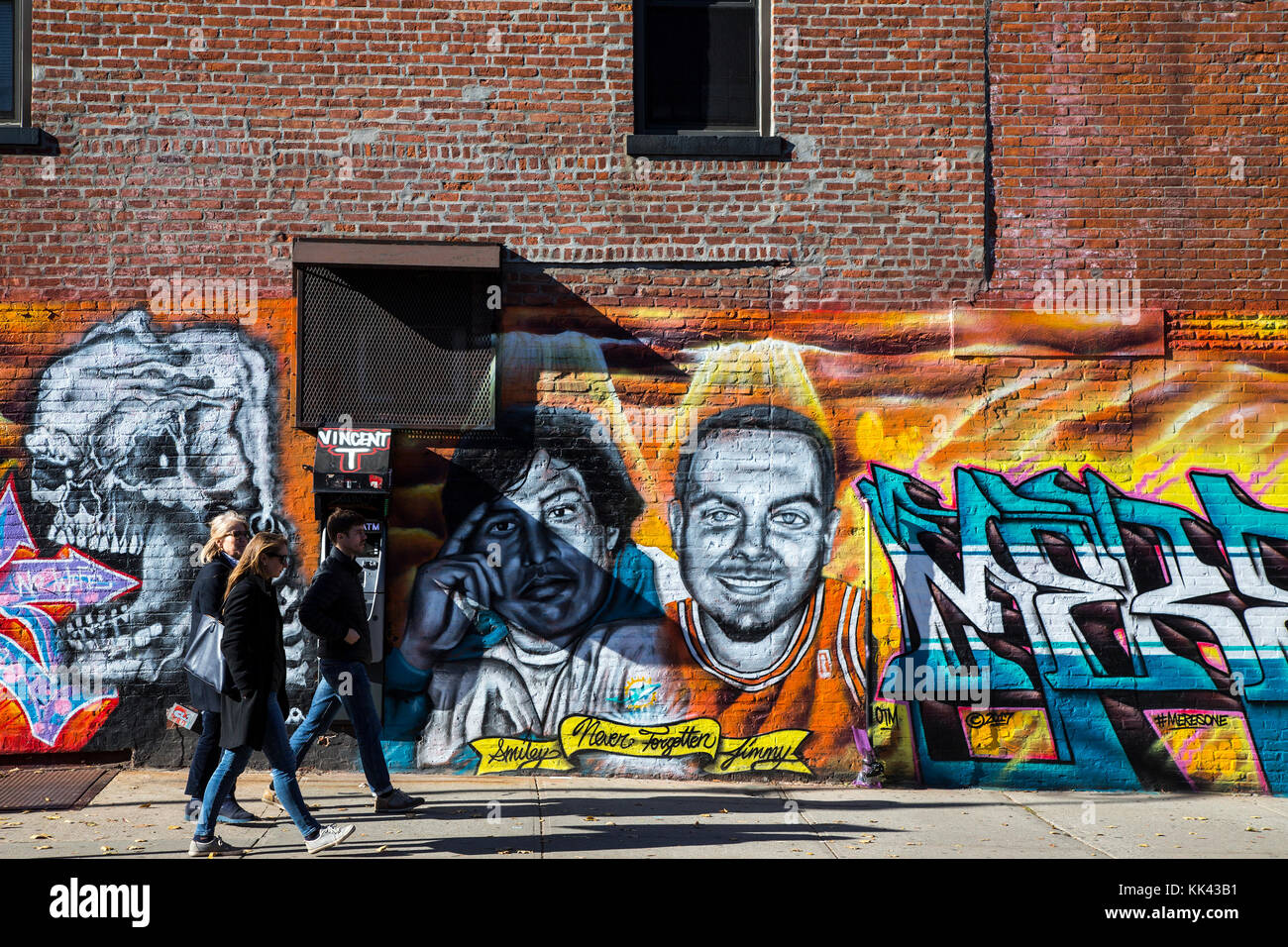People walking past a wall of graffiti in the Carroll Gardens ...