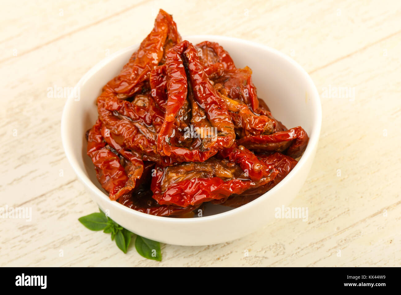 Dried tomato in olive oil with basil leaves Stock Photo - Alamy