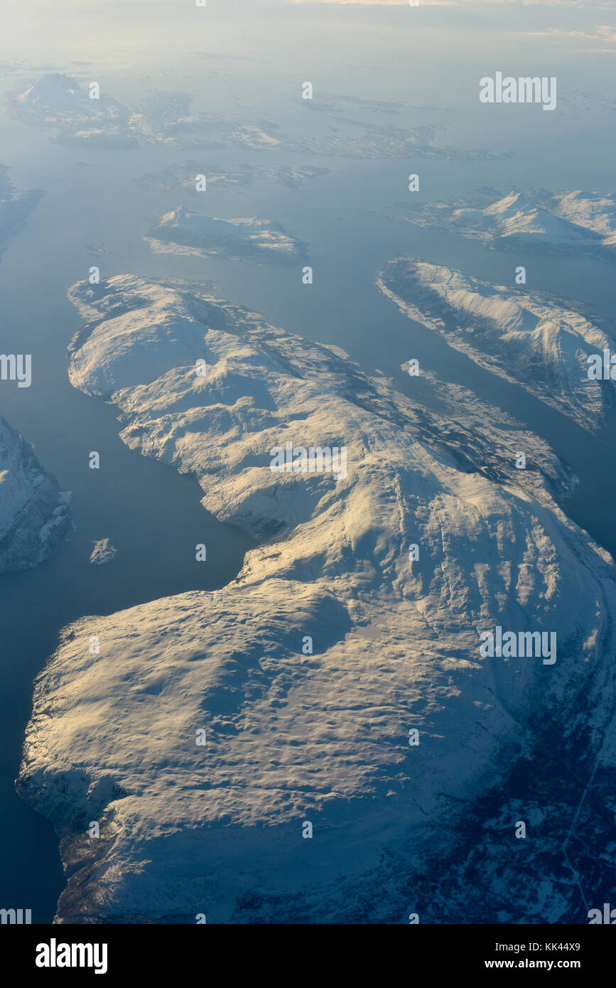 An aerial view of the snow covered mountains of the fjords of Norway in ...