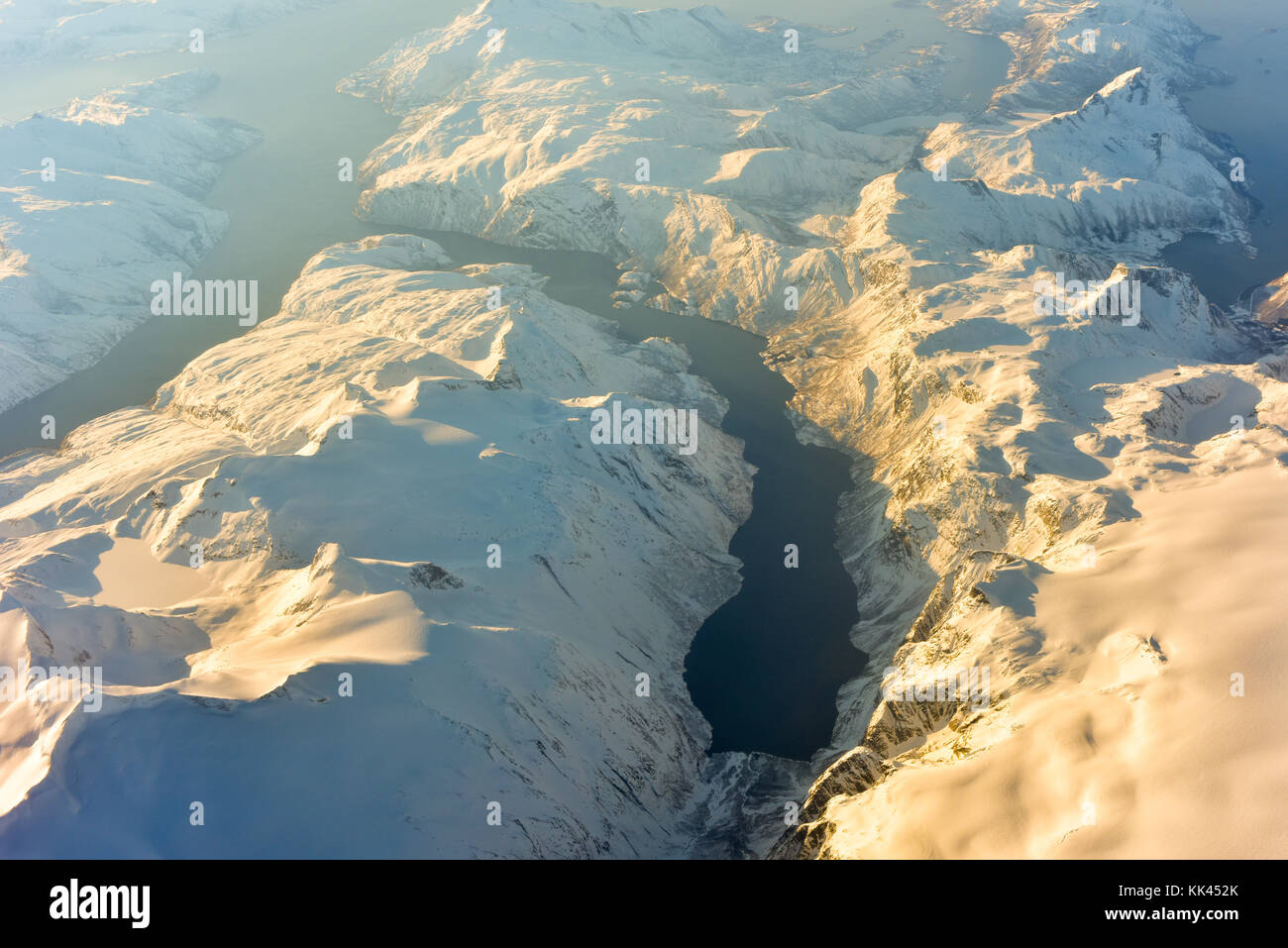 An aerial view of the snow covered mountains of the fjords of Norway in ...