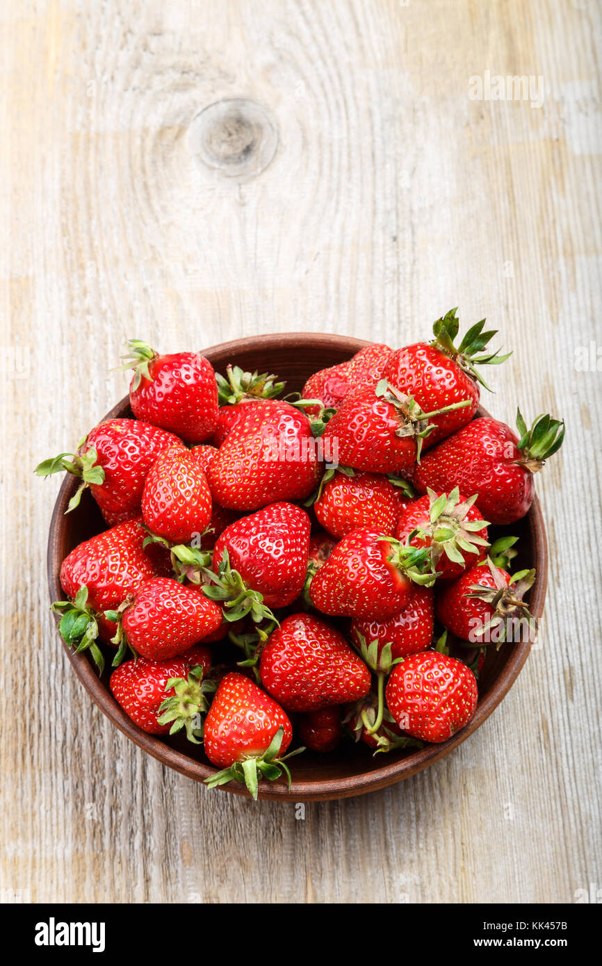 Fresh strawberry in a clay plate on wooden table , top view Stock Photo ...