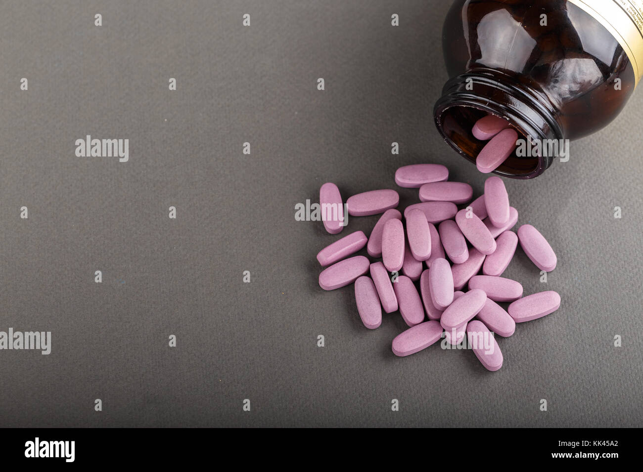 large pink tablets scattered on a black background, space for text ...