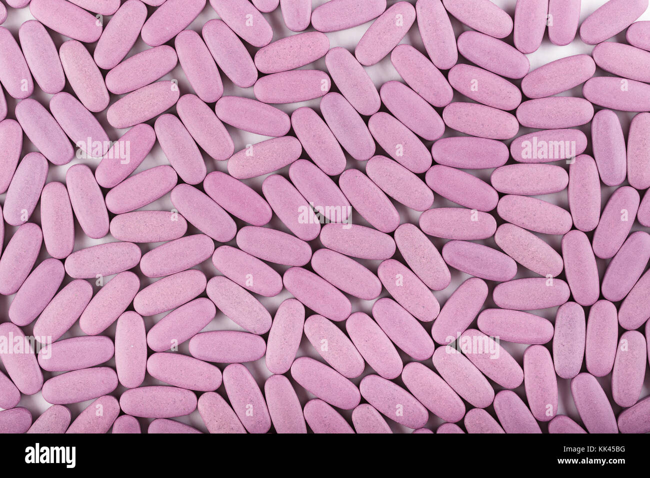 many large pink tablets are scattered as a background, space for text ...