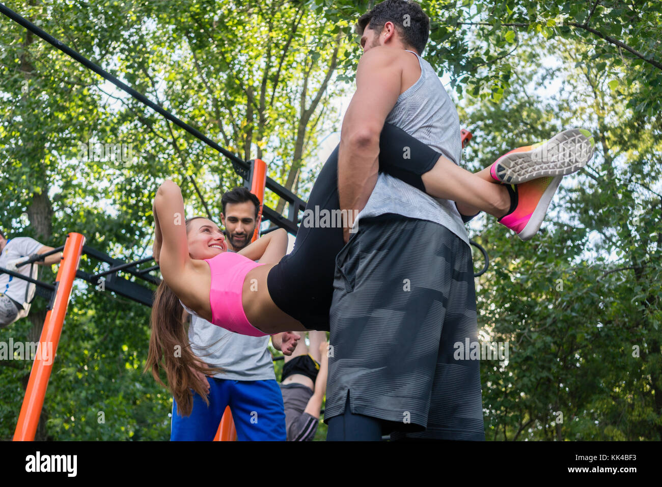 Young fit woman smiling while doing crunches with her partner du Stock ...