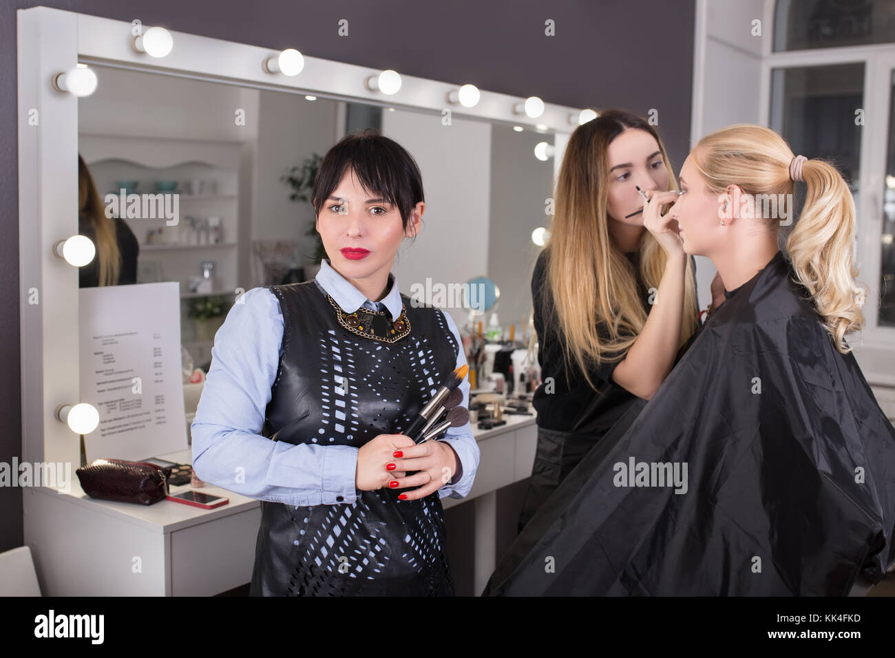 portrait of makeup teacher holding brushes in her studio. Makeup ...