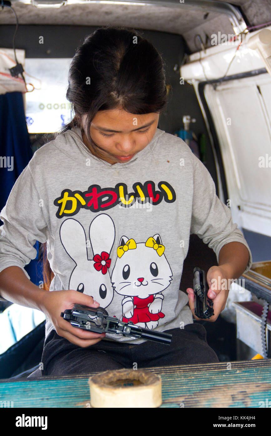 12 year old gunsmith Lisa Wasuwat assists her father Prajak in the ...