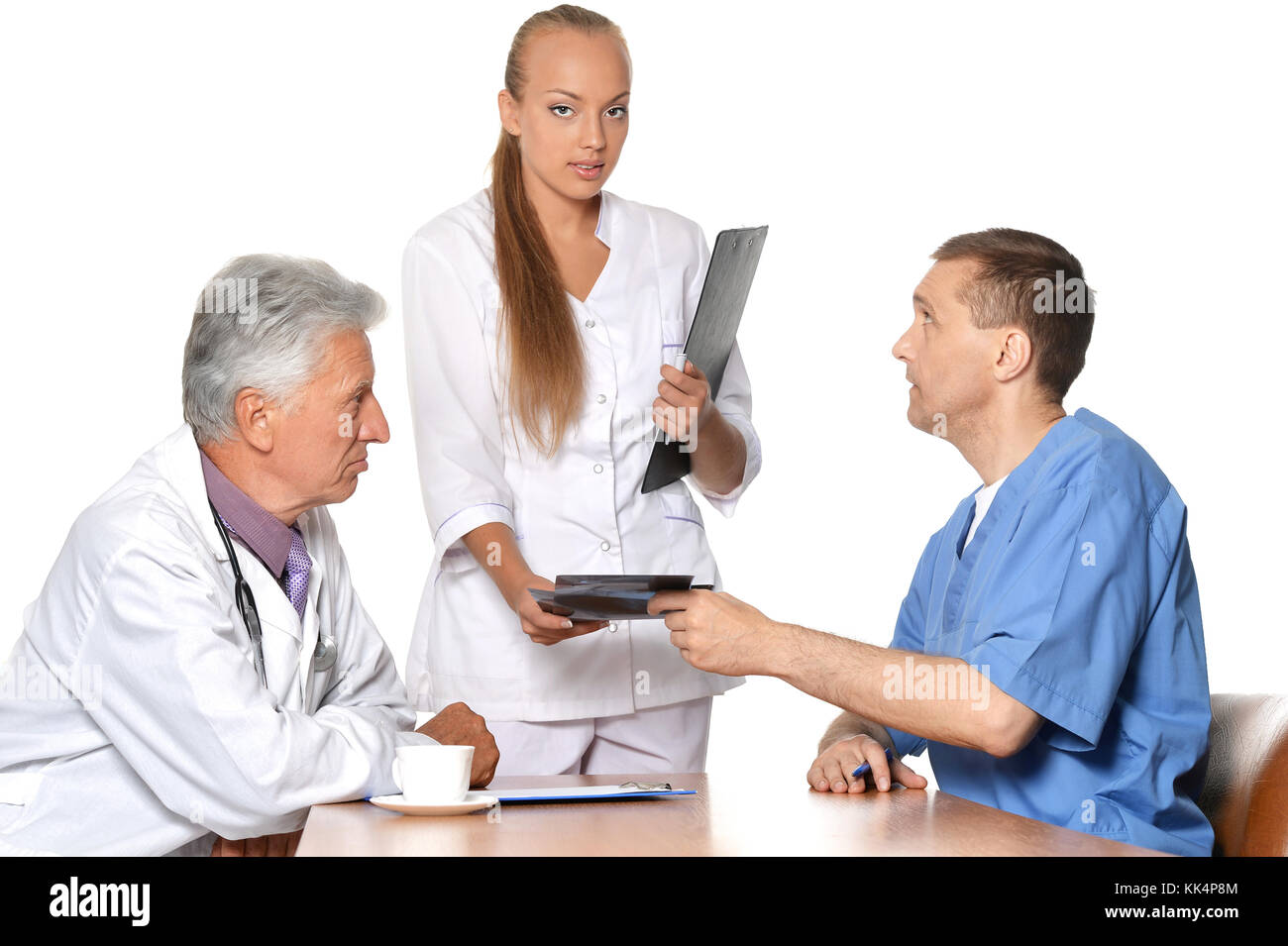 Doctors at table exemining xray Stock Photo - Alamy