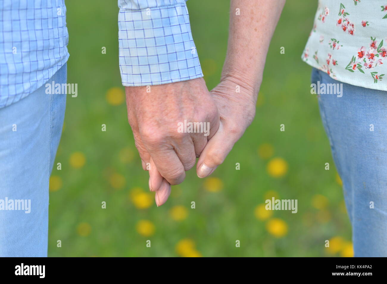 Elderly couple holding hands Stock Photo - Alamy
