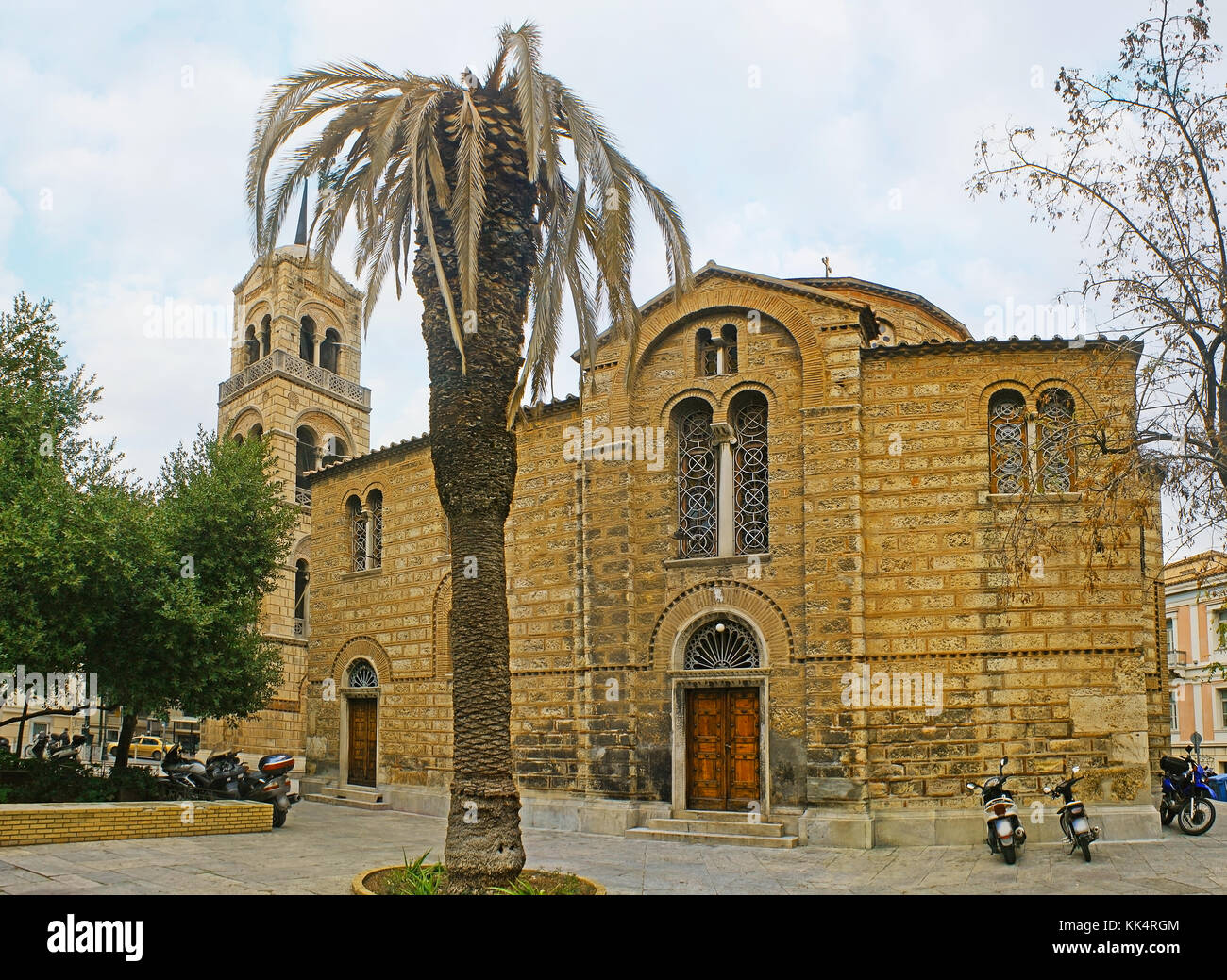The old palm tree in front of the medieval stone building of the ...