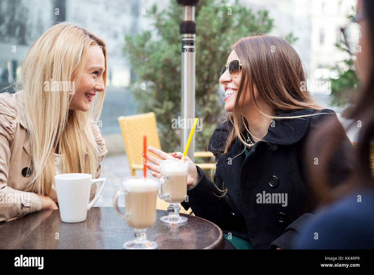 Portrait of beautiful blonde woman talking with her friends at c Stock ...