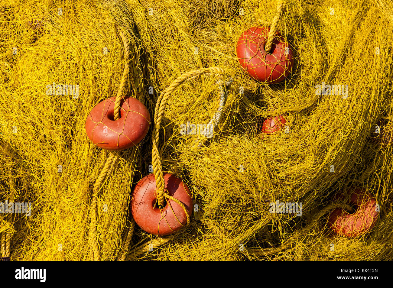 Yellow fishing nets and yellow rope with red buoys in a seaside fishing ...