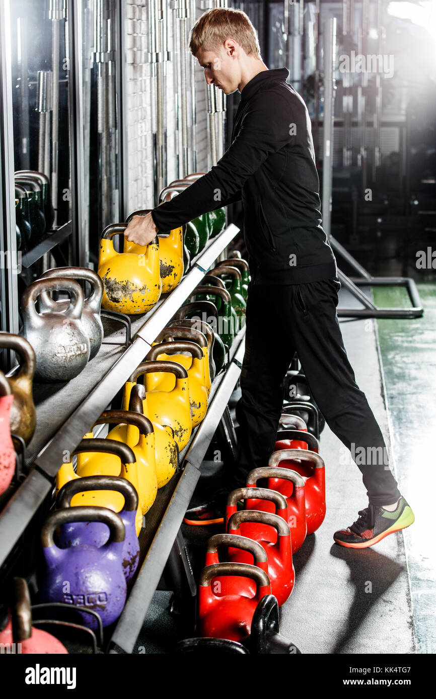 guy removes yellow weights after training in the gym on the window ...