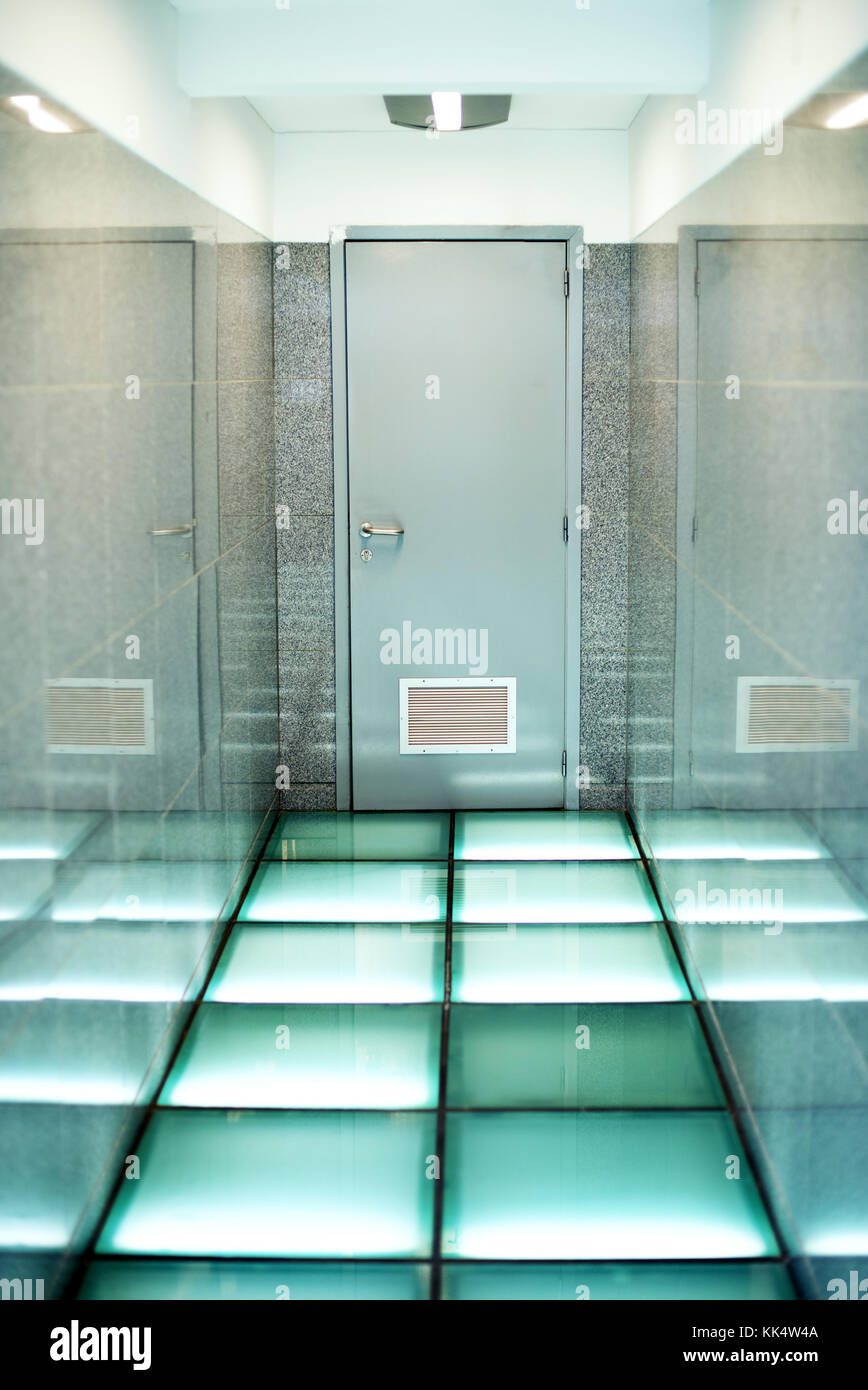 Corridor with glass floor with illumination and door Stock Photo - Alamy