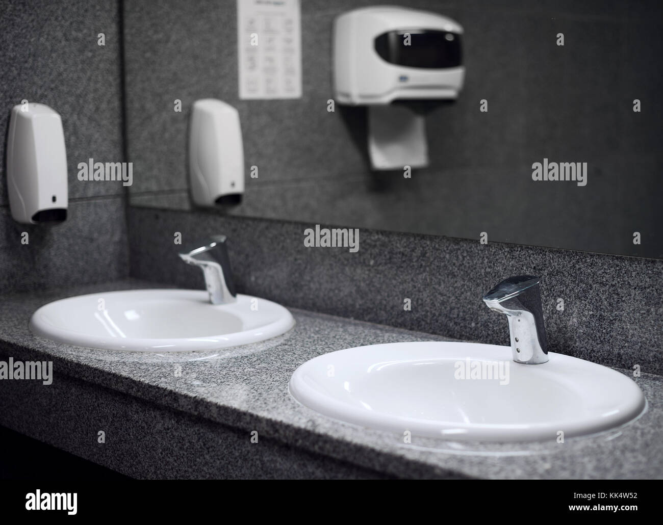 Empty public toilet room with sinks and taps Stock Photo - Alamy