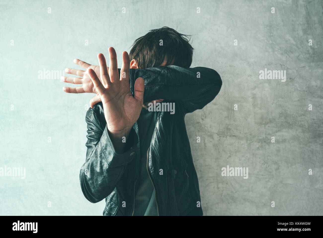 Male protecting face from violent attack. Adult caucasian man covering ...