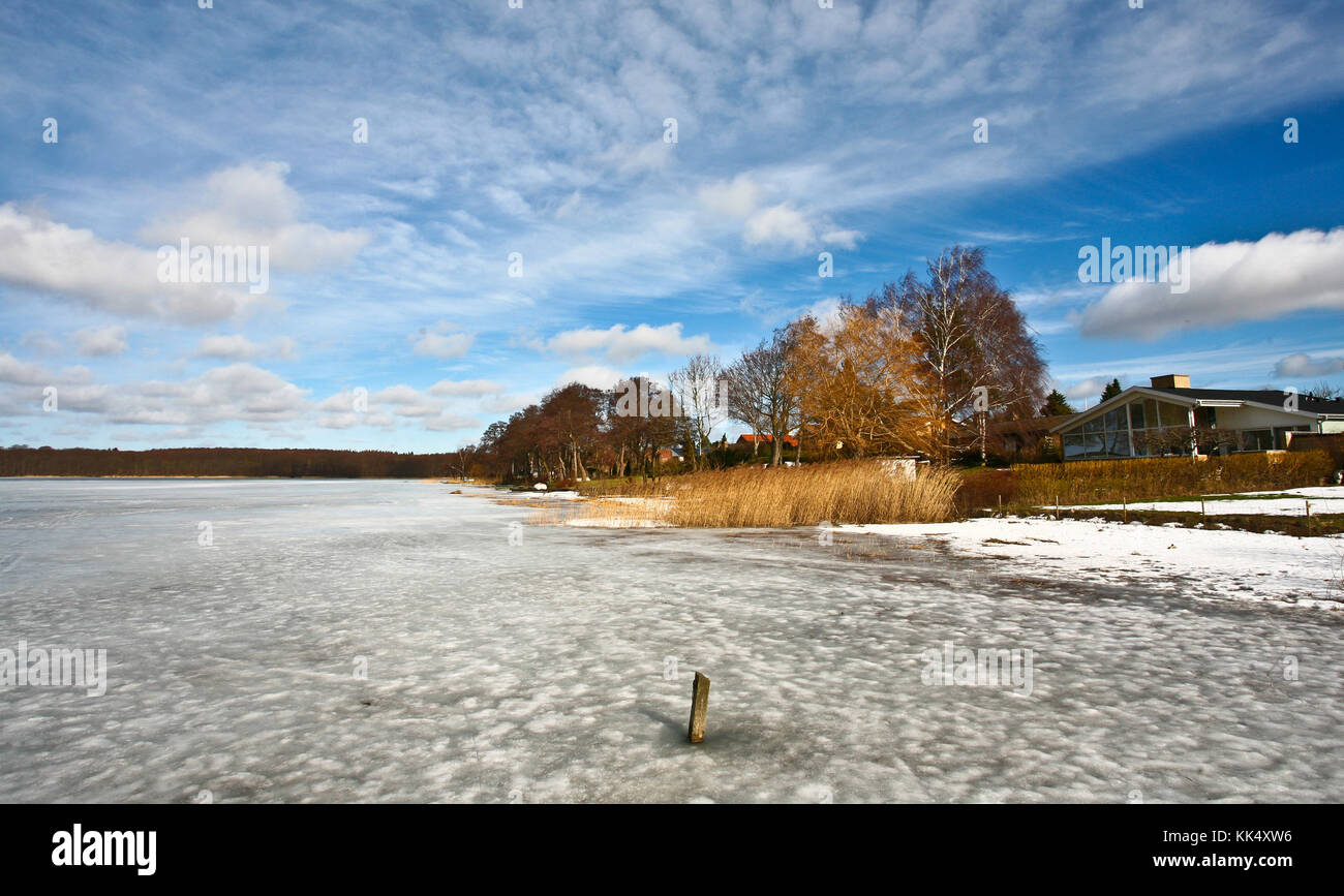 Iced lake in sun in denmark in winter Stock Photo - Alamy
