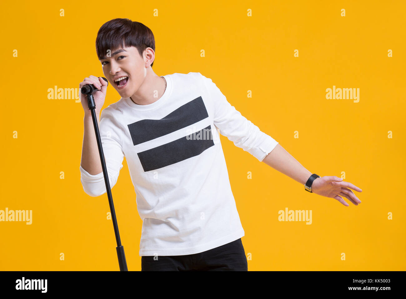Cheerful young Chinese man singing with microphone Stock Photo - Alamy