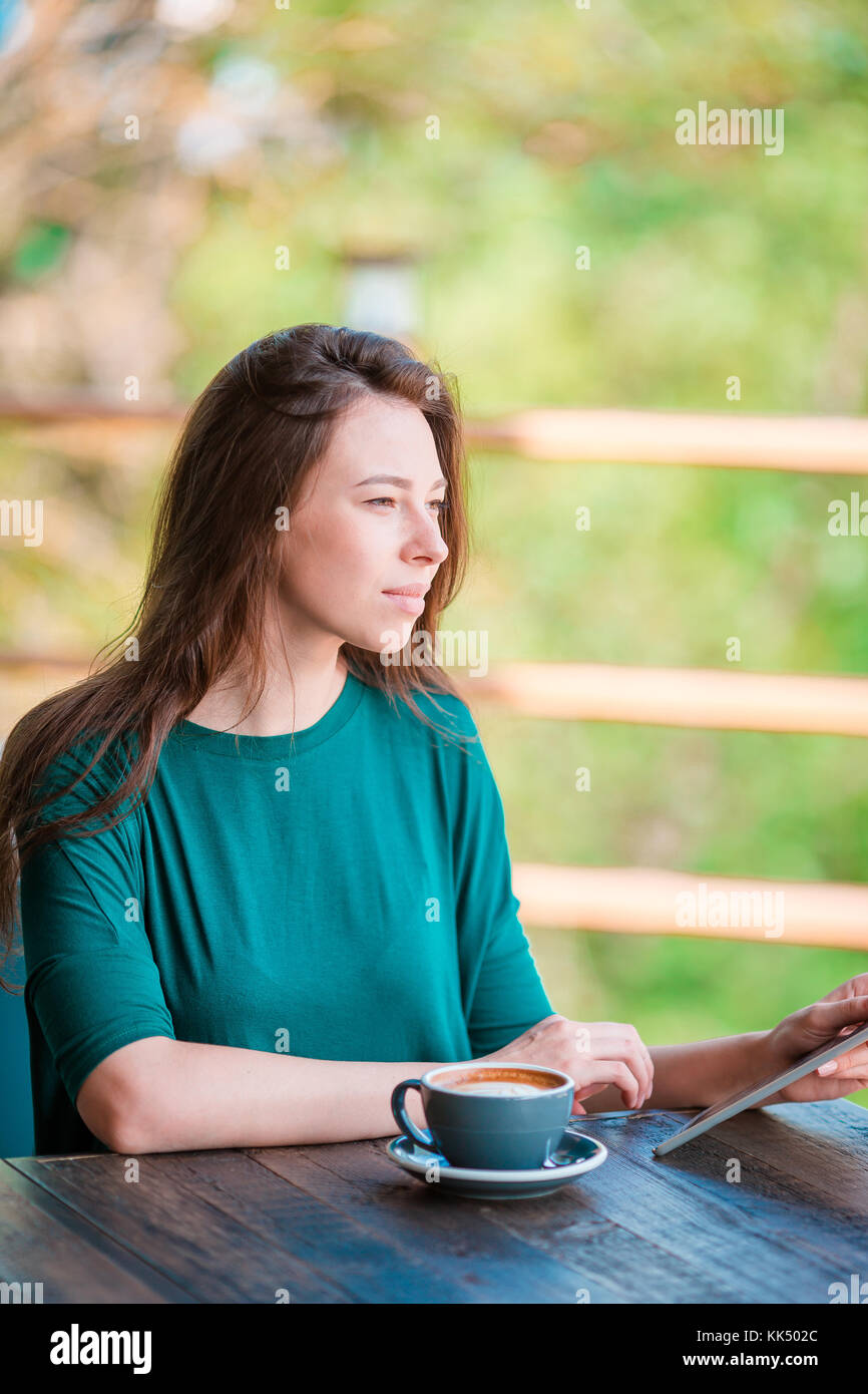 Young charming woman calling with cell telephone while sitting alone in ...