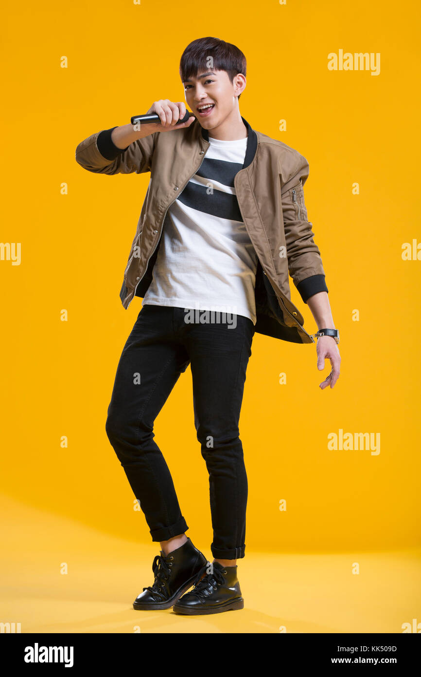 Cheerful young Chinese man singing with microphone Stock Photo - Alamy