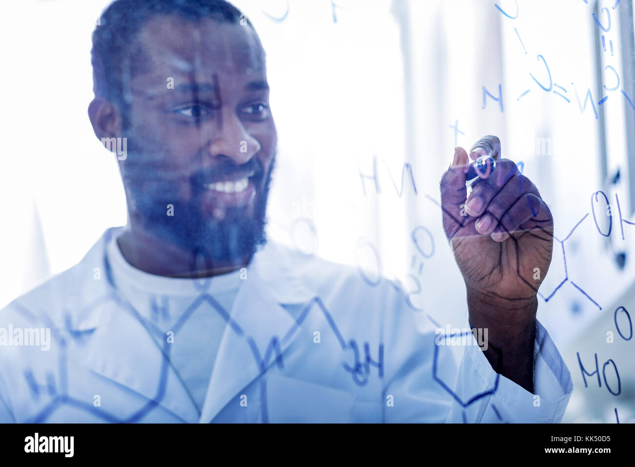 Cheerful nice man inventing a formula Stock Photo - Alamy