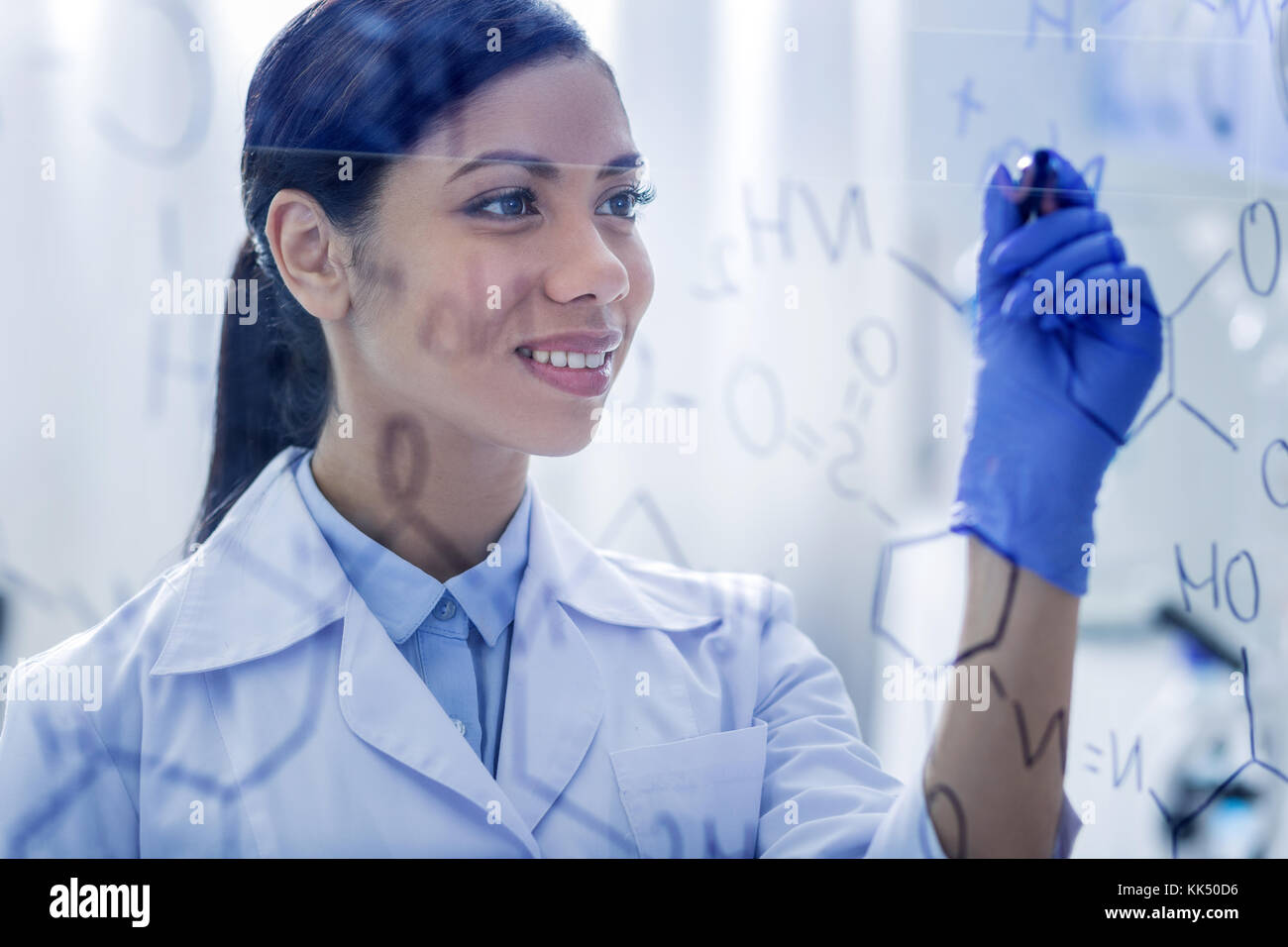 Happy smart woman writing a formula Stock Photo - Alamy