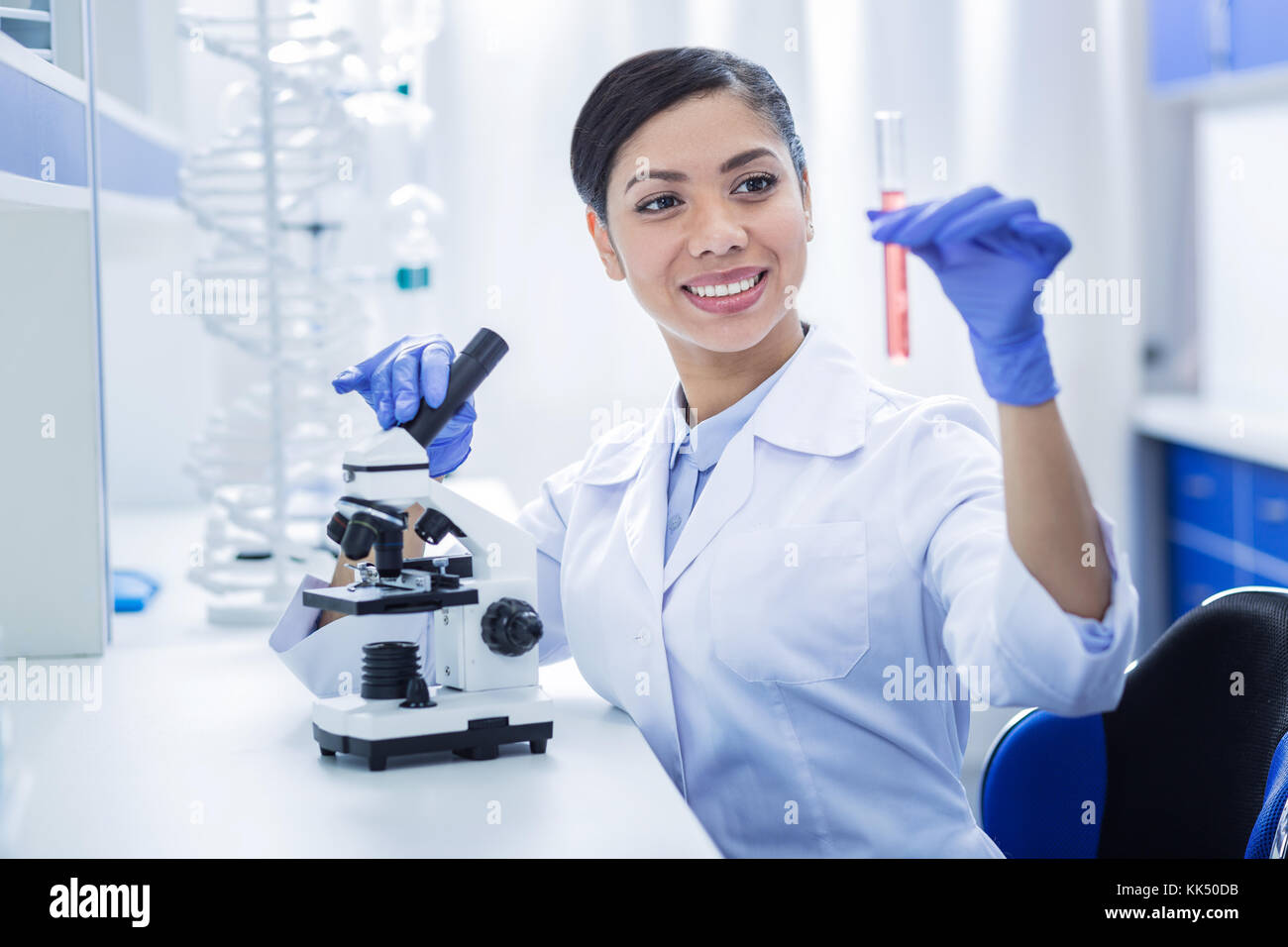 Happy young woman holding a test tube Stock Photo - Alamy
