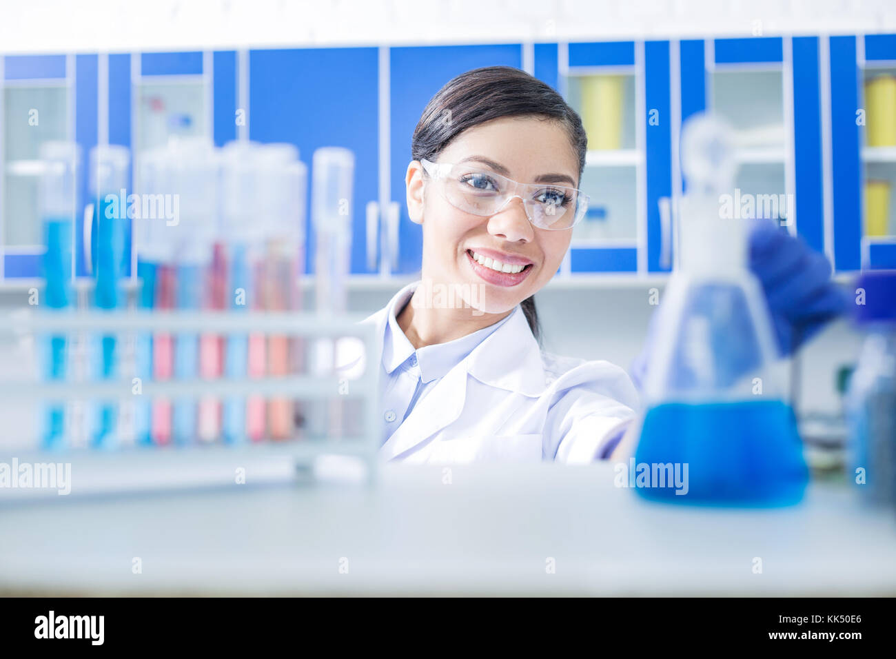 Nice happy woman working in the chemical lab Stock Photo - Alamy