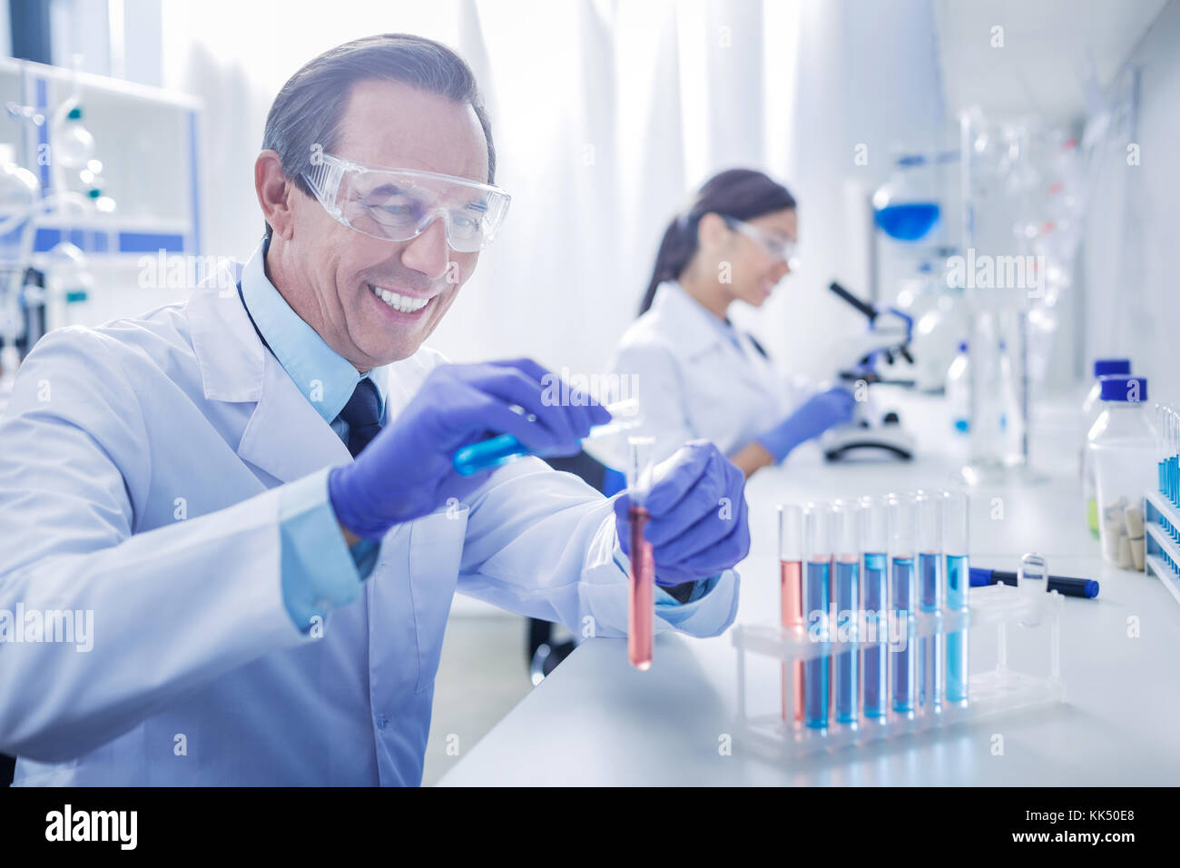Happy intelligent man working in the chemical lab Stock Photo - Alamy