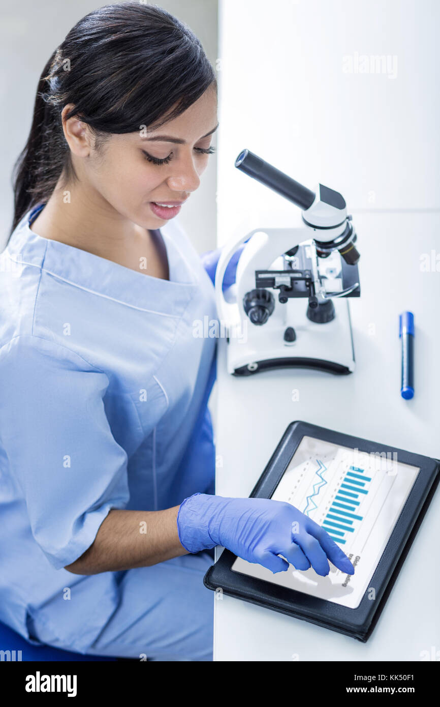 Positive young woman looking at the tablet screen Stock Photo - Alamy